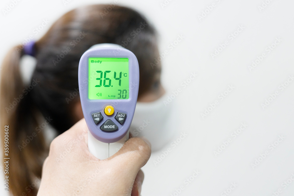View of Hand Using Infrared Thermometer Gun Checking Woman Forehead for ...