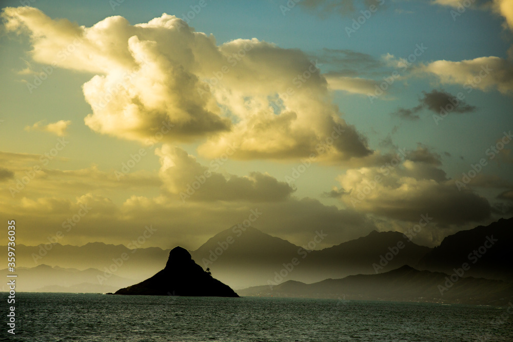 A dark threatening sky above Mokolii, commonly known as Chinaman's Hat ...