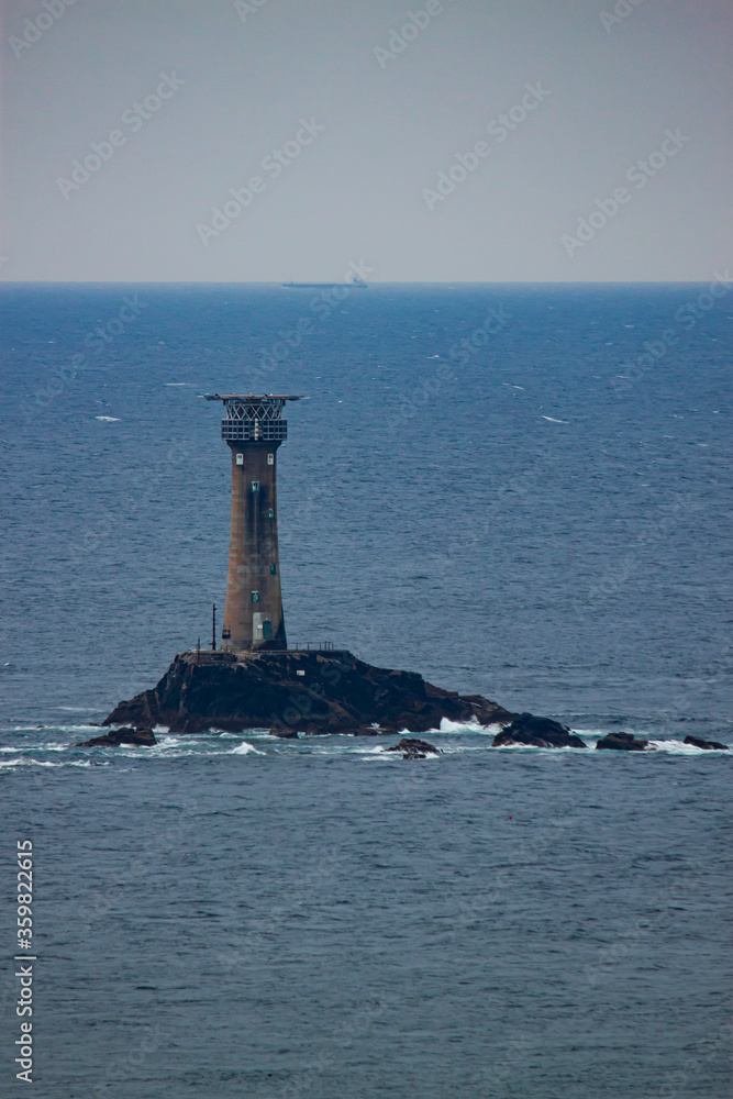 Close up image of a lighthouse on top of a little rock in the middle of ...