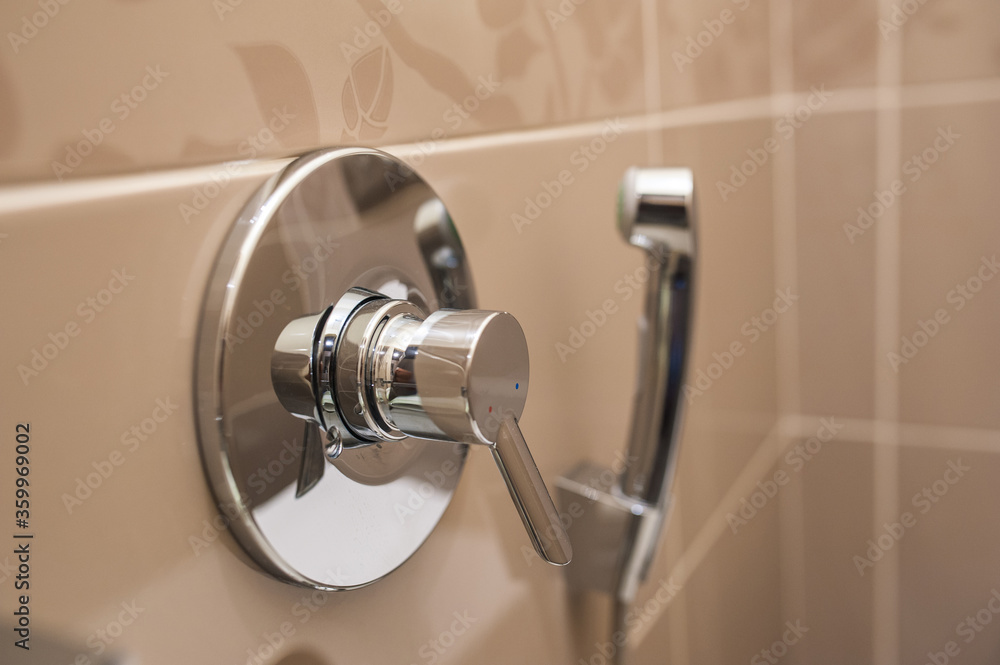 Hygienic shower with tap on the tiled wall in the toilet. Intimate ...