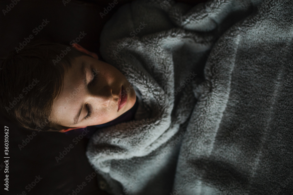Teen boy cozy and covered in blanket Stock Photo | Adobe Stock