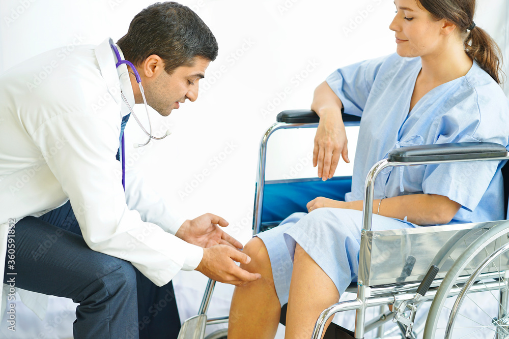 A doctor concentrate touching lady patient leg to check bone in ...
