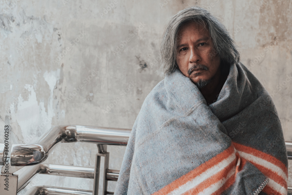 Homeless man standing on walkway in town. Stock Photo | Adobe Stock