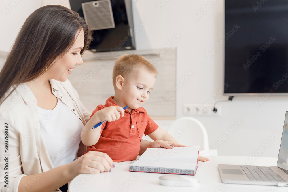 Beautiful woman helps son learn how to write alphabet letters. Online ...