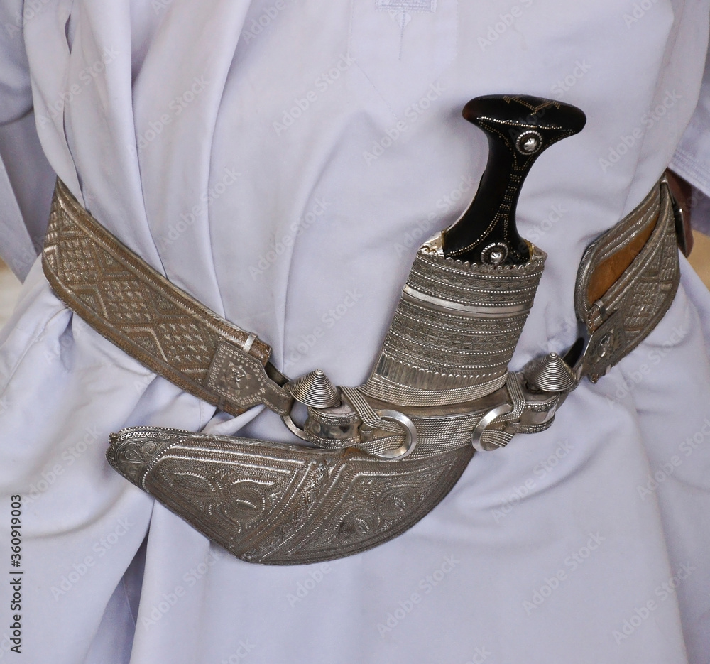 Silver belt and khanjar (dagger) worn over a dishdasha (traditional ...