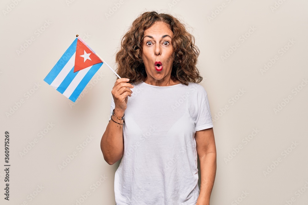 Middle age beautiful tourist woman holding cuban flag over isolated ...