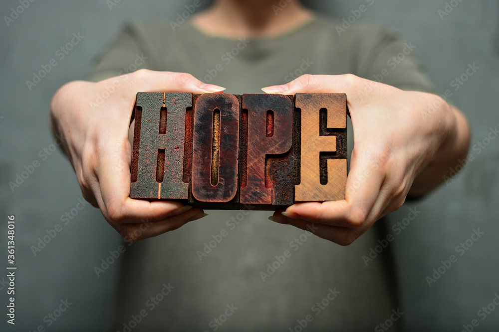 Woman holding the word "hope" made of wooden typographic letters ...