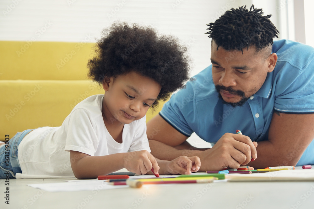 Fotografie Black African American family dad son together at home. Young father lying on the ...