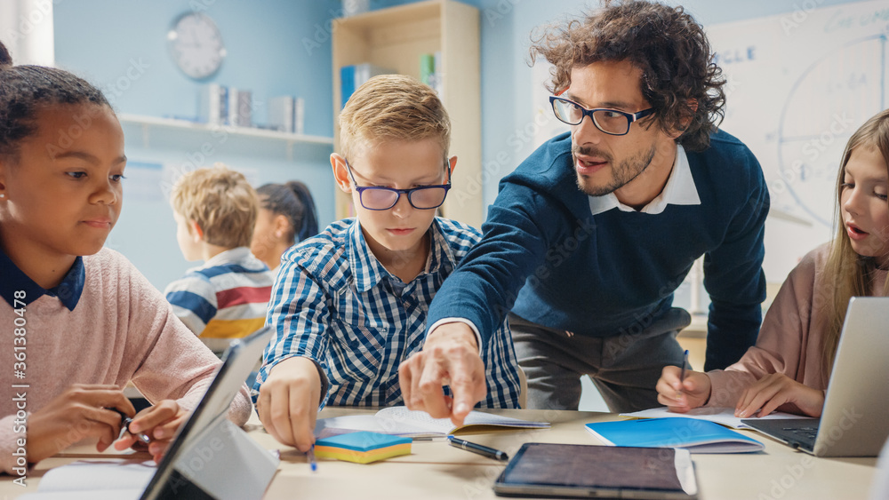 Elementary School Classroom: Enthusiastic Teacher Using Tablet Computer ...
