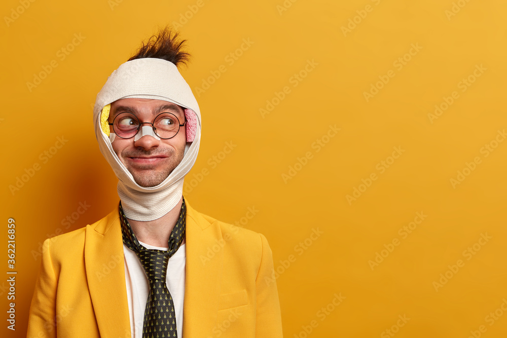 Funny smiling man with shiner under eye looks away, has serious head ...