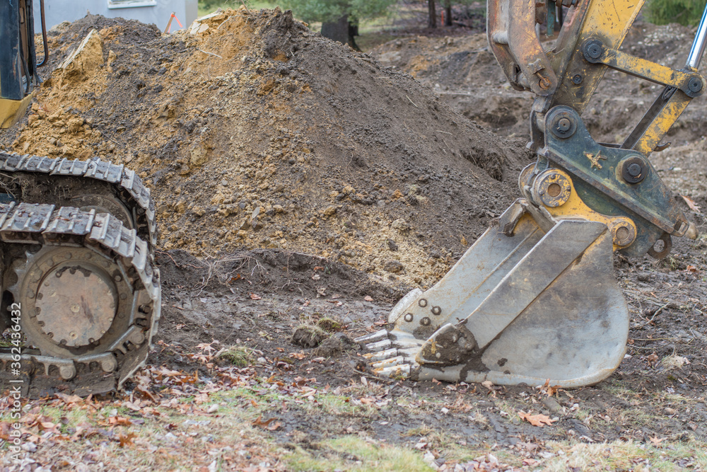 Bucket of backhoe tractor at house construction site digging foundation ...
