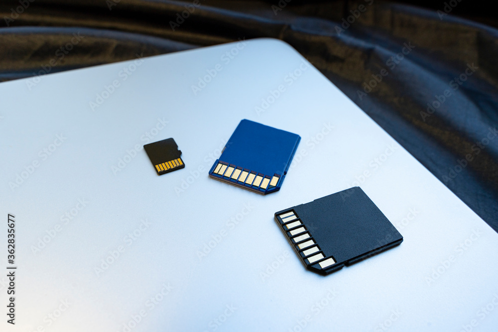 blue and black memory cards on silver laptop surface, close-up. concept ...