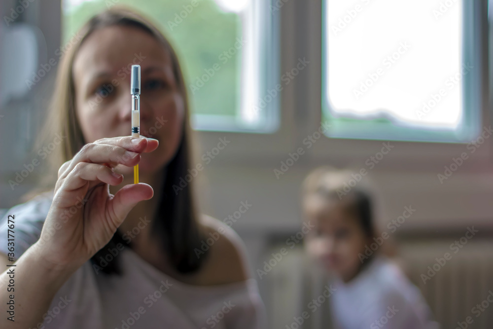 Photo Stock Young mother showing syringe to her daughter ready to ...