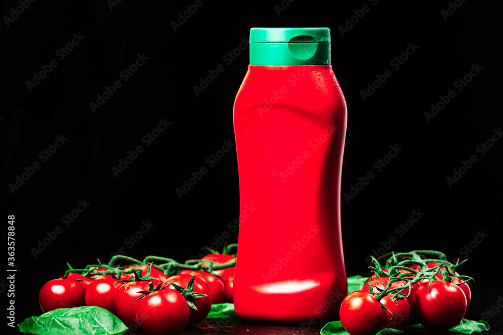 bottle, tube of red ketchup with a green cap and two ripe branches of ...