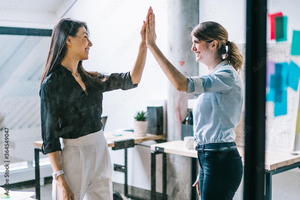 Happy professional office employees giving five each other after great ...