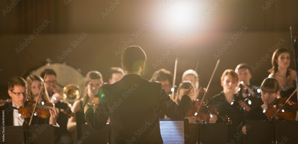 Conductor leading orchestra Stock Photo | Adobe Stock
