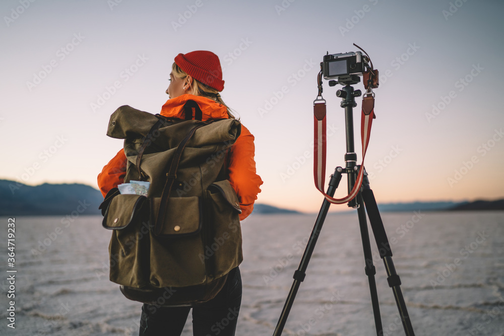 Back view of female photographer with backpack making preparation ...