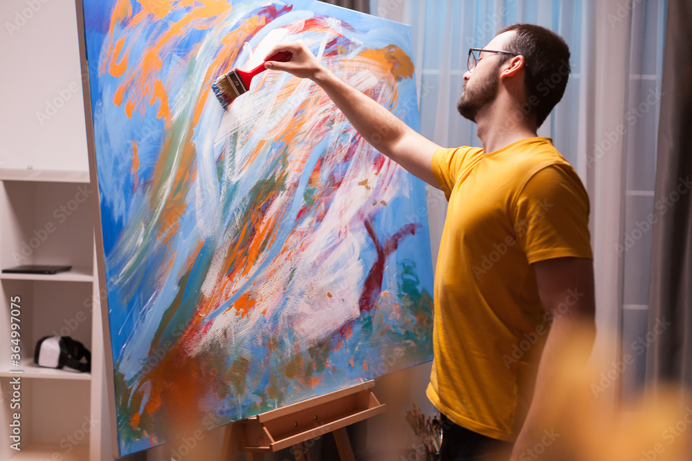 Man painting a masterpiece on large canvas in art studio. Modern ...