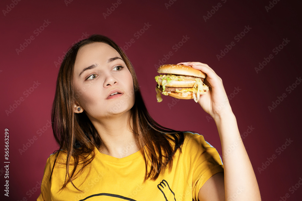 Overeating fast food. Woman secretly eating a Burger. Comic photo of ...