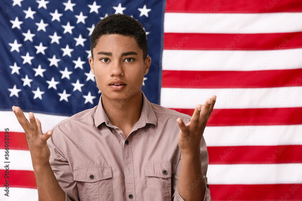 Stressed African-American teenage boy near national flag of USA. Stop ...
