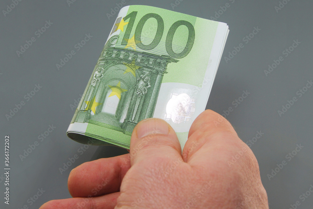 Stack of euros money in hand, hundred euro banknotes in cash on dark ...