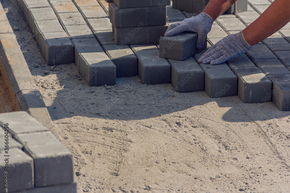 Construction of pavement near the house. Bricklayer places concrete ...