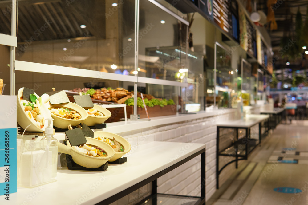 Noodle stall in urban food court with clear acrylic barrier installed ...