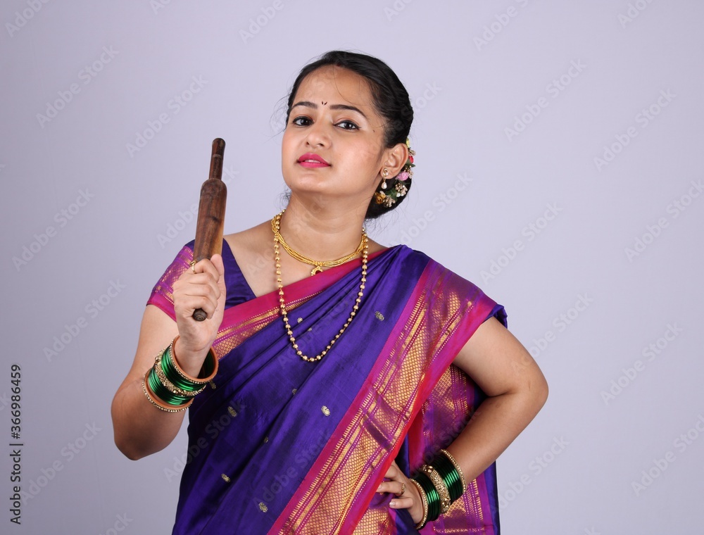 Beautiful Indian woman or girl holding rolling pin in hand. This is ...
