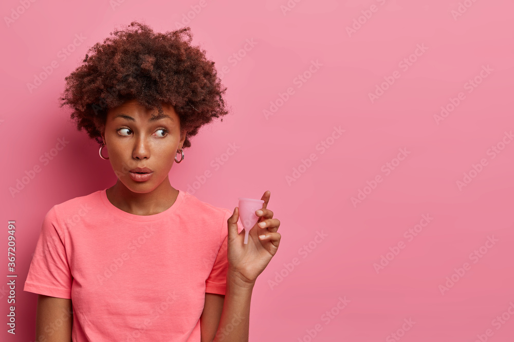 Surprised young woman poses with feminine hygiene device that is ...