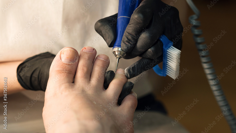 Foto Hardware pedicure, preparation of the nail plate for applying gel ...