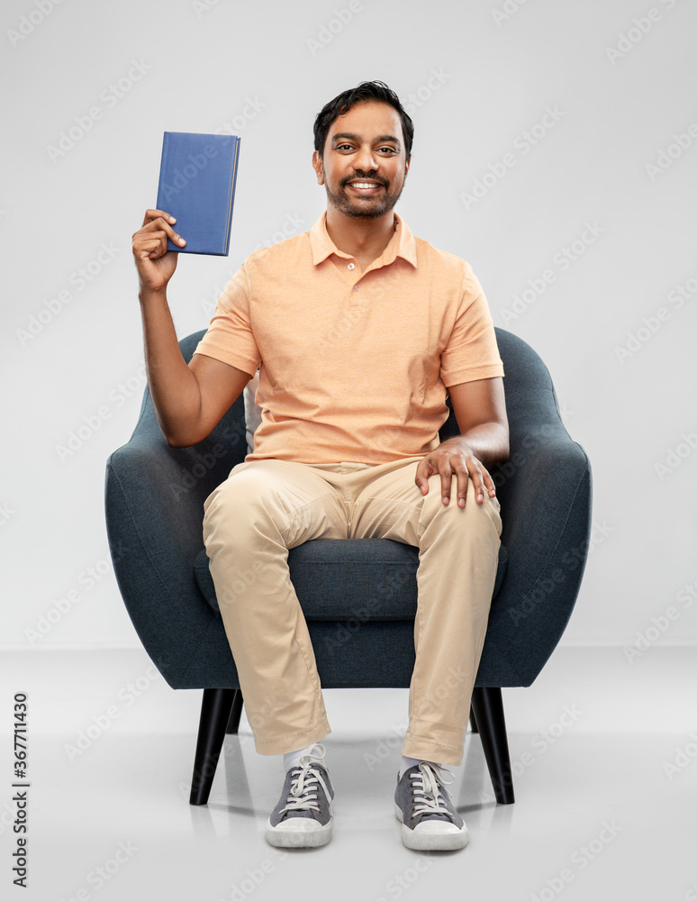 people and reading concept - happy smiling young indian man sitting in ...