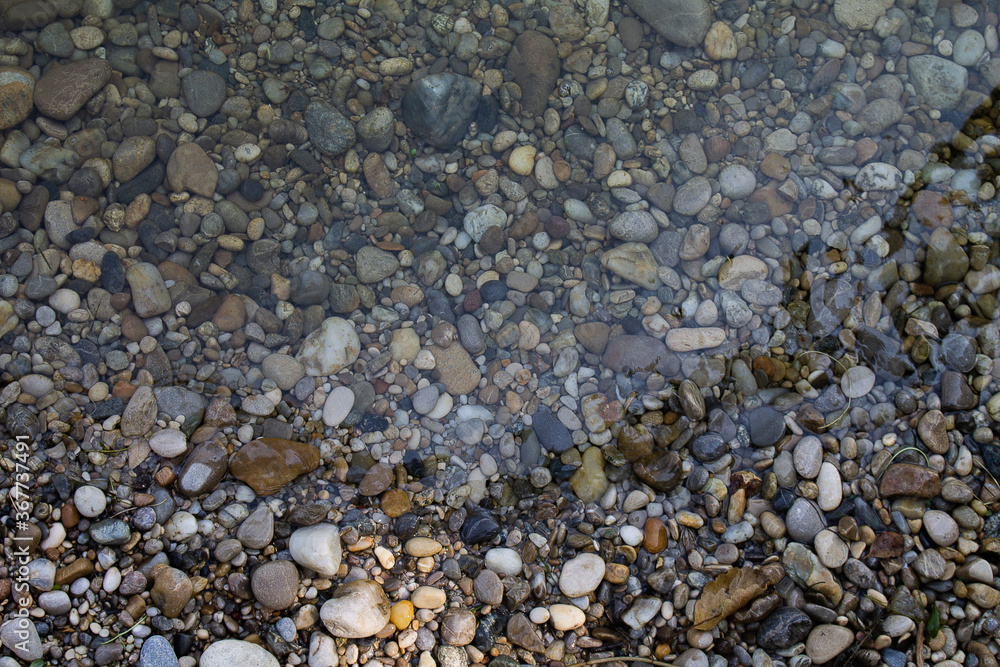 Texture of river pebbles half under water. Stock Photo | Adobe Stock