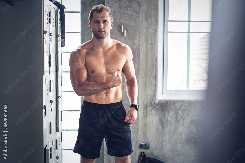 Stock-Foto „Portrait of Caucasian man showing his biceps muscle at gym ...