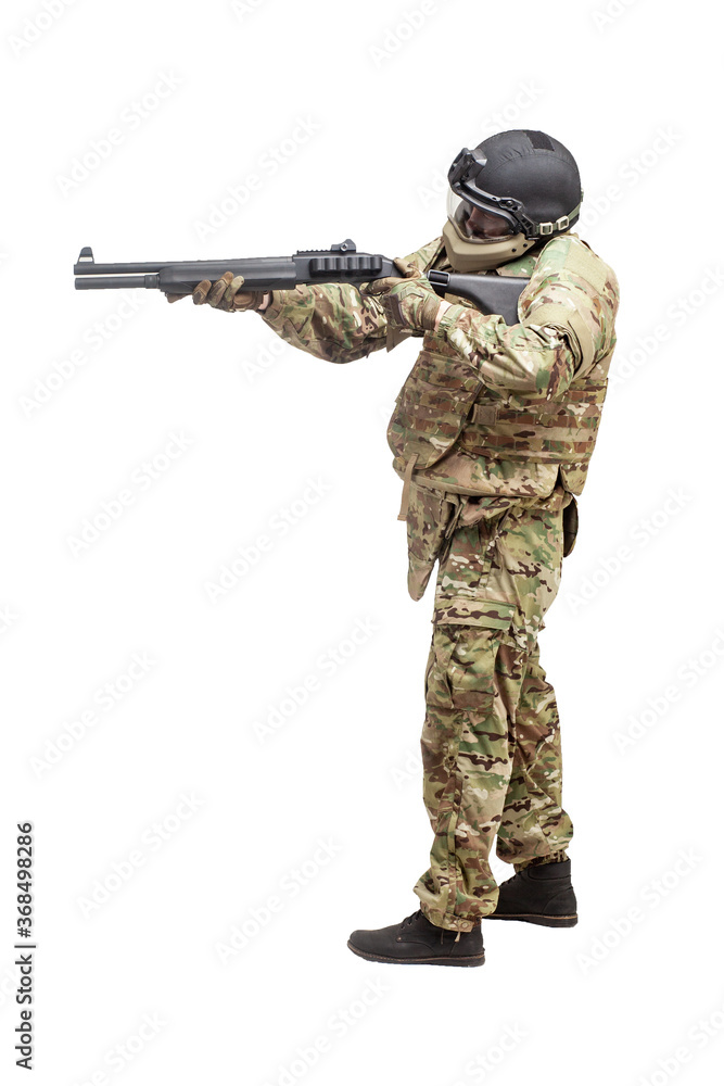 military commando in uniform with a shotgun attacks and aims on a white ...