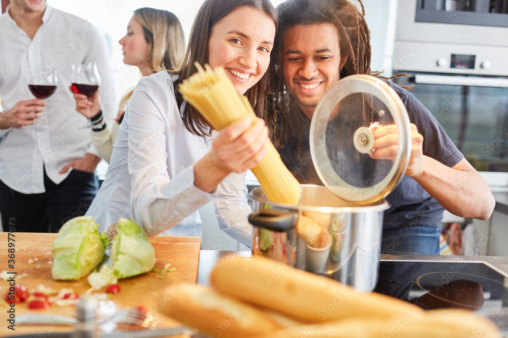 Friends or couple cooking pasta in shared kitchen Stock Photo | Adobe Stock