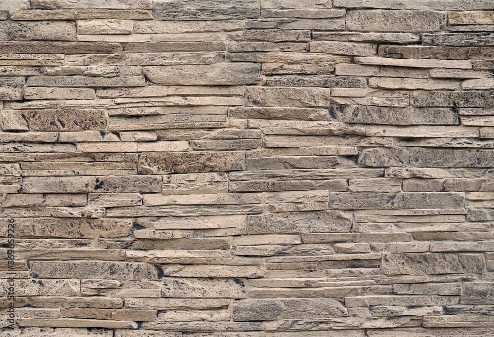 Stone cladding wall made of striped stacked thin slabs of natural brown ...