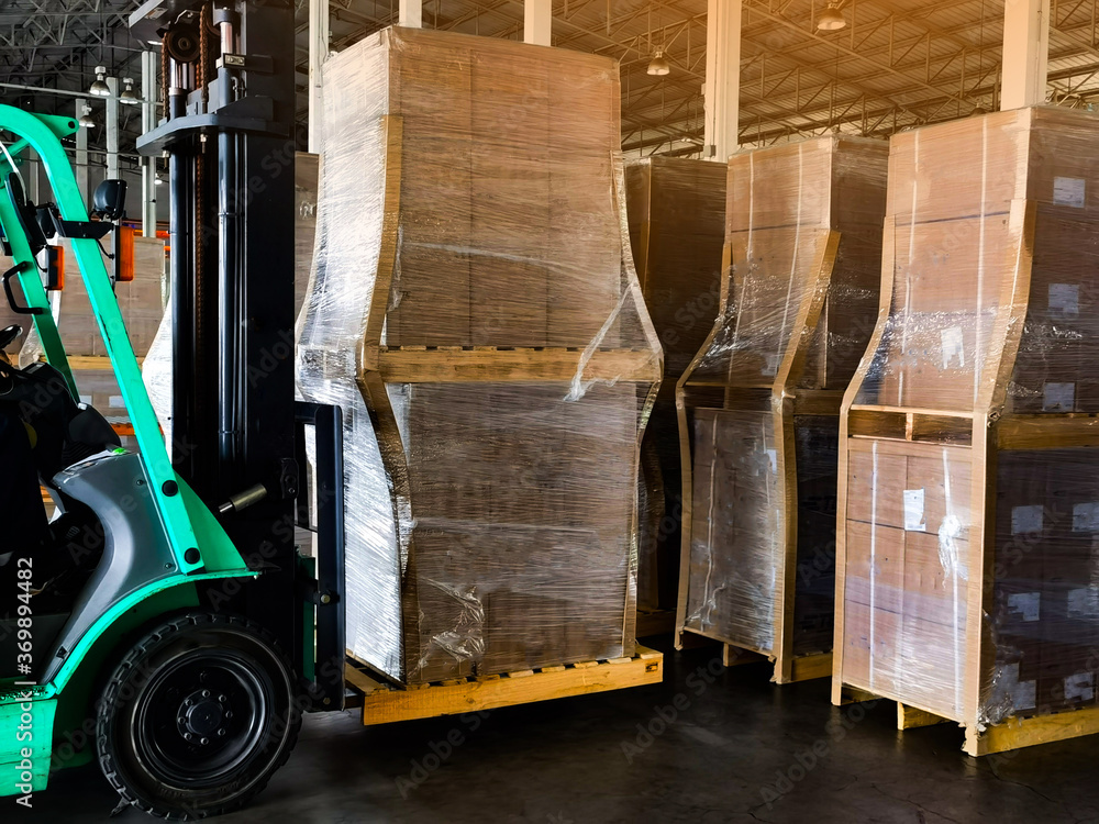 Worker driving forklift loading and unloading shipment carton boxes and ...