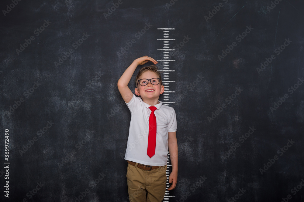 Little kid boy measuring himself. School boy measuring his growth in ...