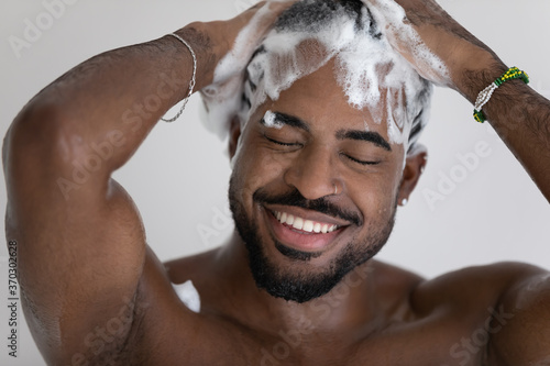Close up smiling African American handsome young man washing cleaning ...