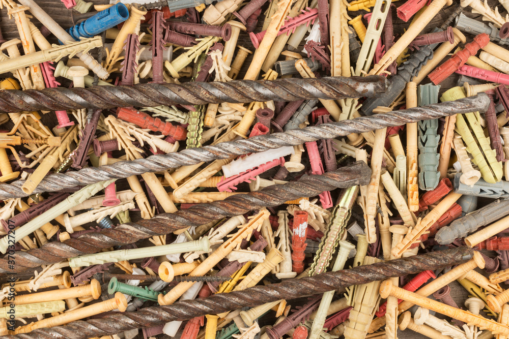 Old drills for drilling concrete lies on a pile of dowels. Construction ...