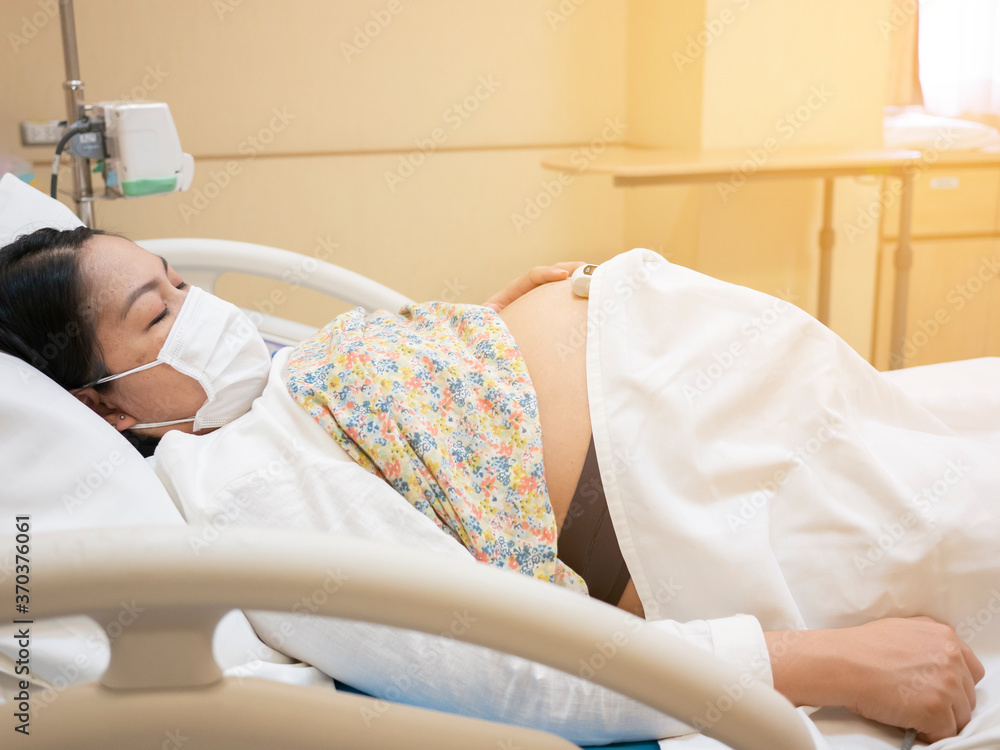Asian pregnant woman lying on a hospital bed to check the health of the ...
