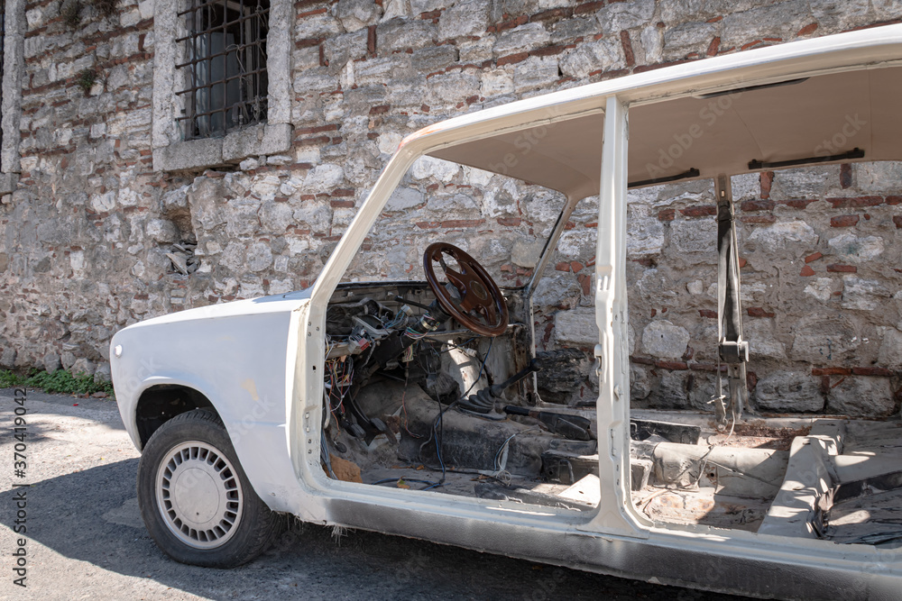 an old model scrap white vehicle abandoned with panels, doors, seats ...