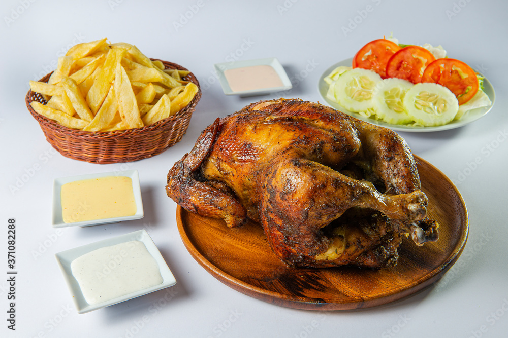 Delicious whole grilled chicken with french fries, salad and creams on ...