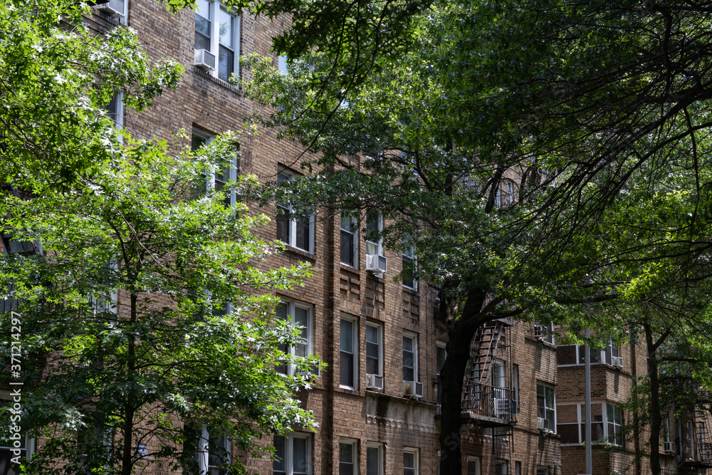 Basic Old Brick Apartment Building Exterior with Green Trees and Fire ...