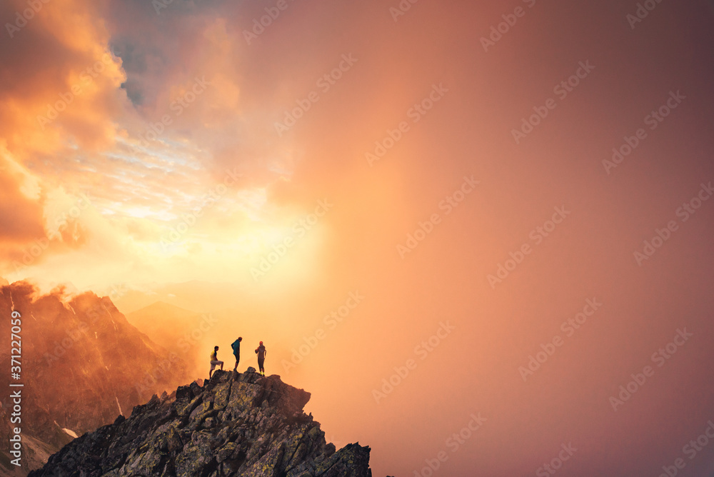 Together overcoming obstacles as a group of three people up on the top ...