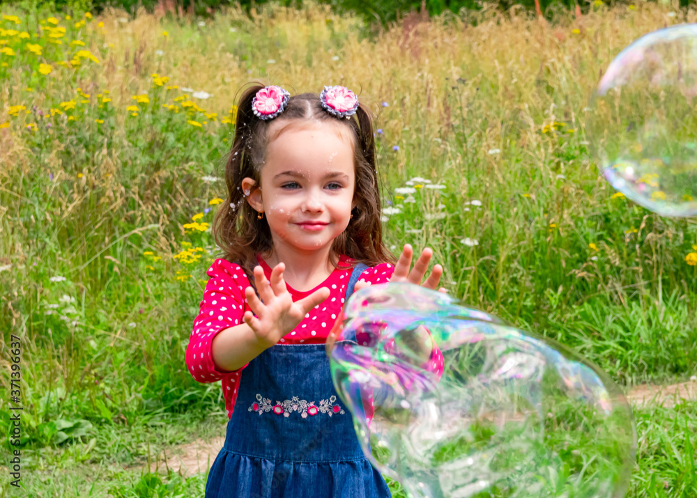 Foto de Stock Funny little girl catching soap bubbles in the summer on ...