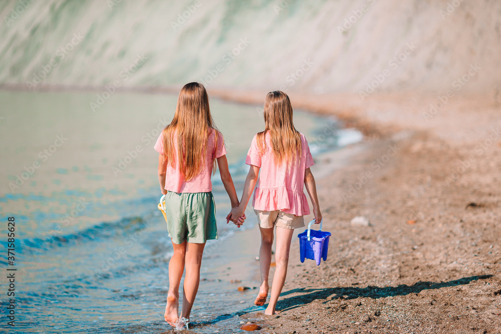 Adorable little girls having fun on the beach Stock Photo | Adobe Stock