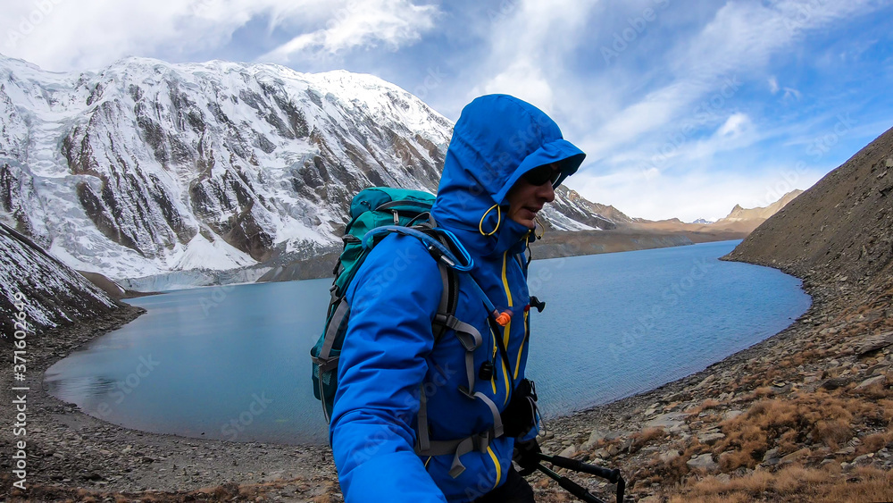 Man taking a selfie with turquoise colored Tilicho lake in Himalayas ...