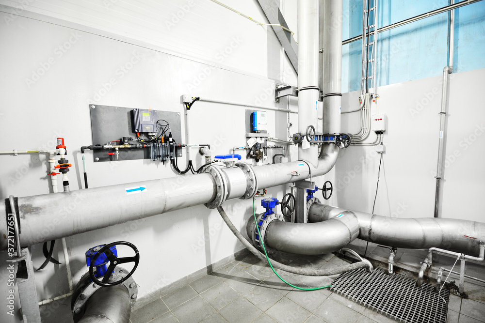 Large blue tanks in a industrial city water treatment boiler room. Wide ...