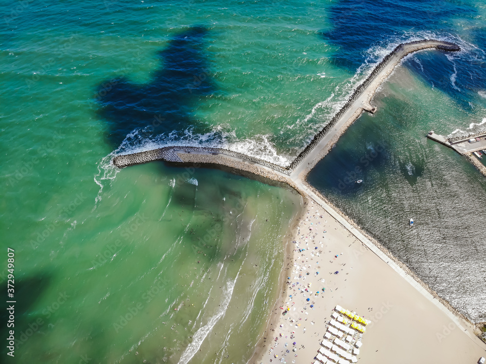 Aerial top view of sea with white stone docks crossing. Light beaches ...